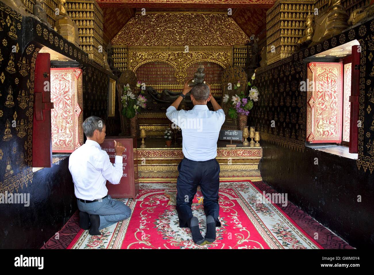 U.S President Barack Obama lifts a Buddha statue over his head, a ...