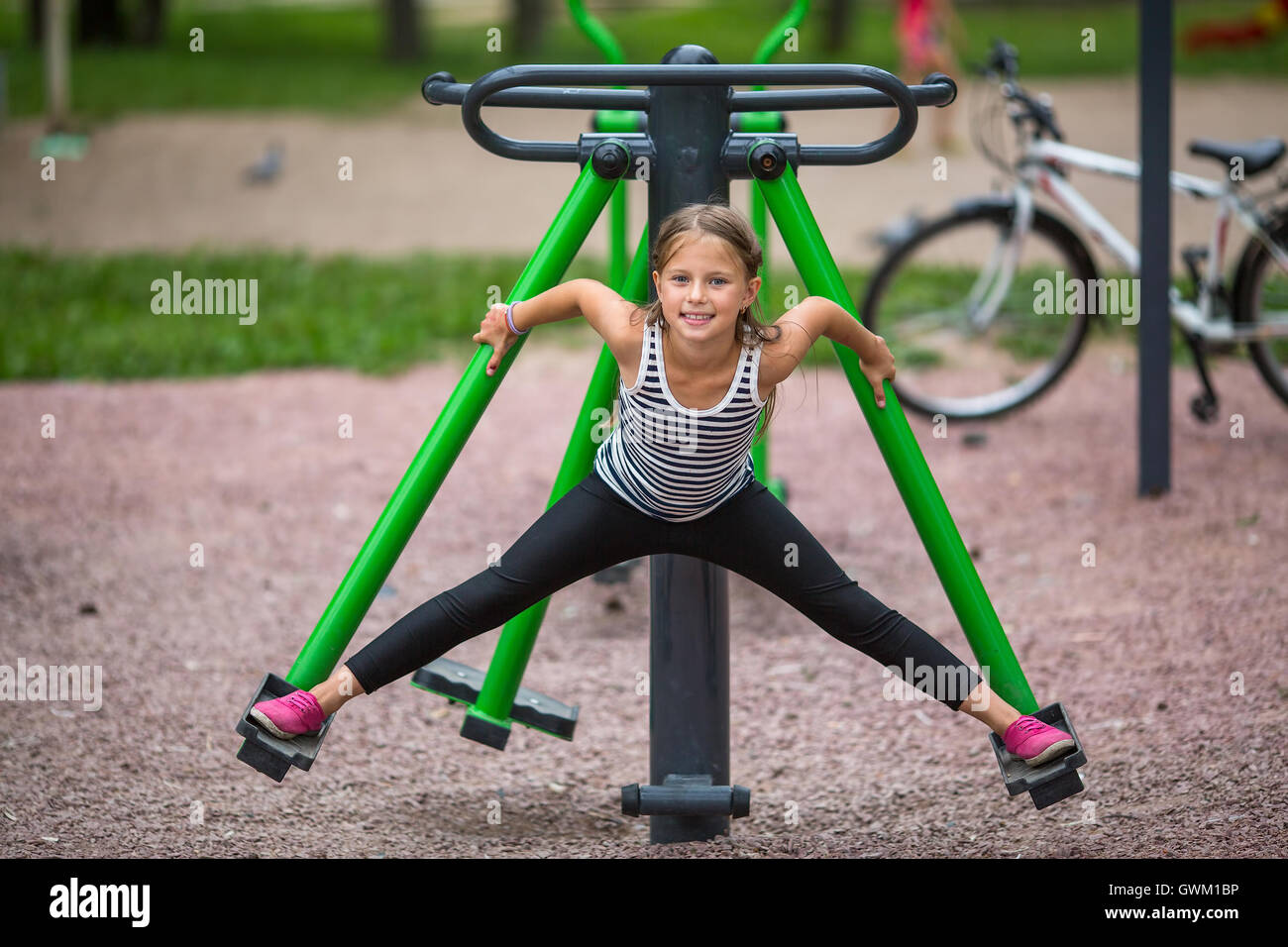 Little girl is engaged in fitness equipment outdoor Stock Photo - Alamy