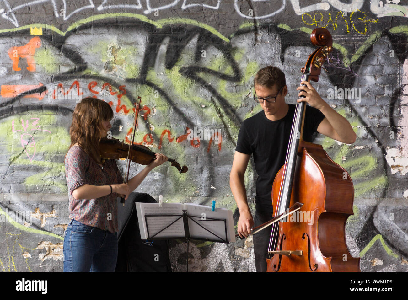 A pair of musicians busking under a railway bridge on Clink Street ...