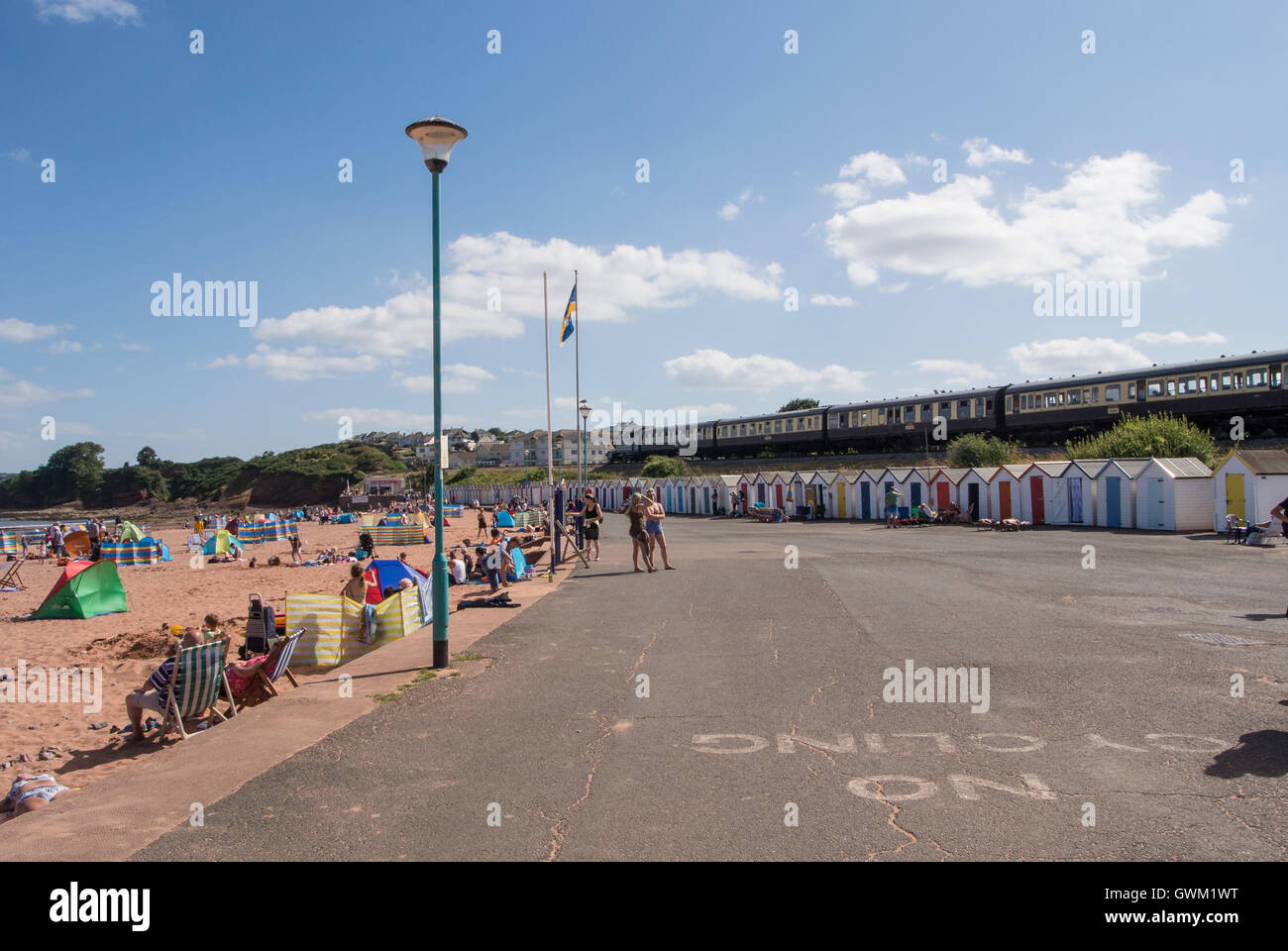 People enjoy the sunshine at Goodrington Sands beach as a stream train ...
