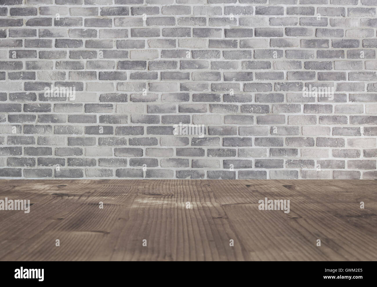 Image of wooden table in front of grey brick wall. Empty table and ...