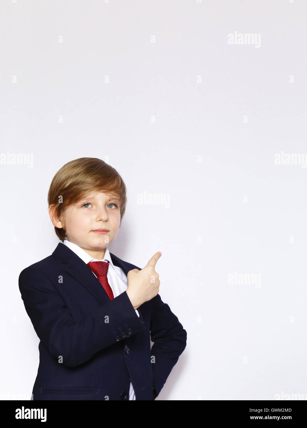 Portrait of a boy in a suit with alarm clock athlete showing pointing ...