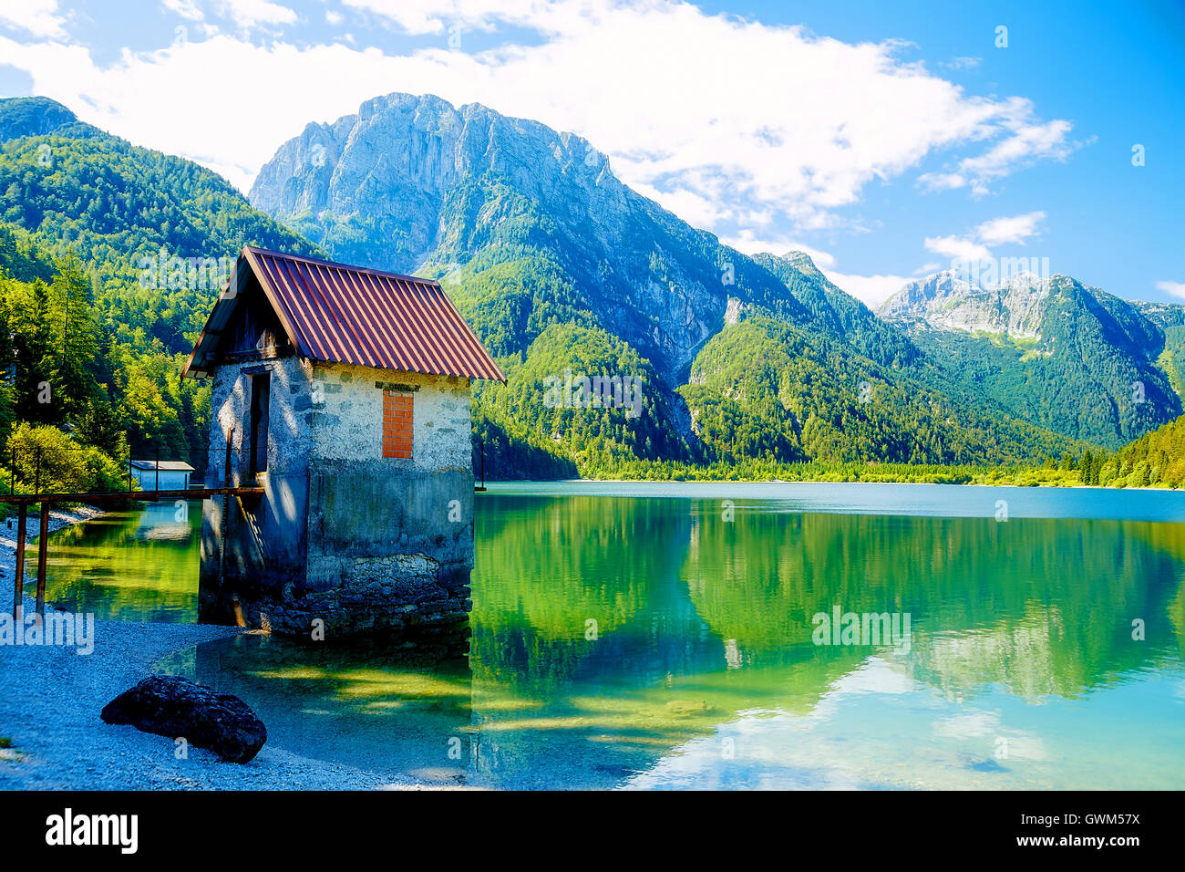 small building at a beautiful lake surrounded by stunning mountain ...