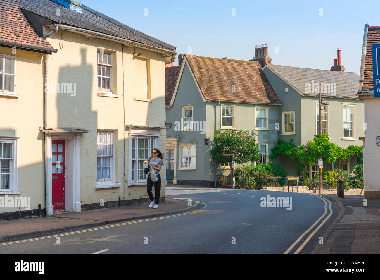 Suffolk village Clare, a young woman walks along Nethergate Street in ...