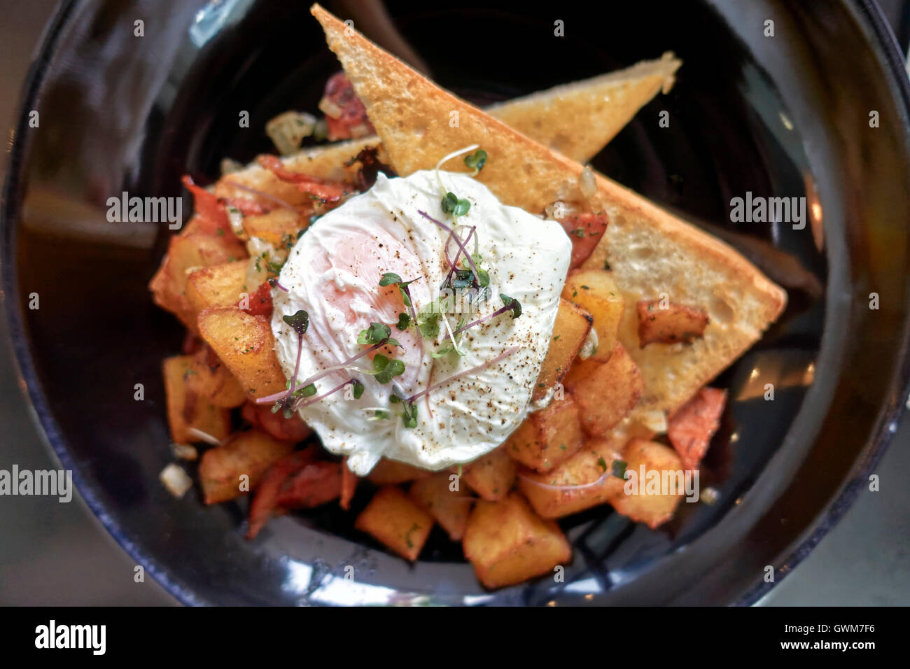 Potatoe hash with crispy bread and poached egg topping Stock Photo - Alamy