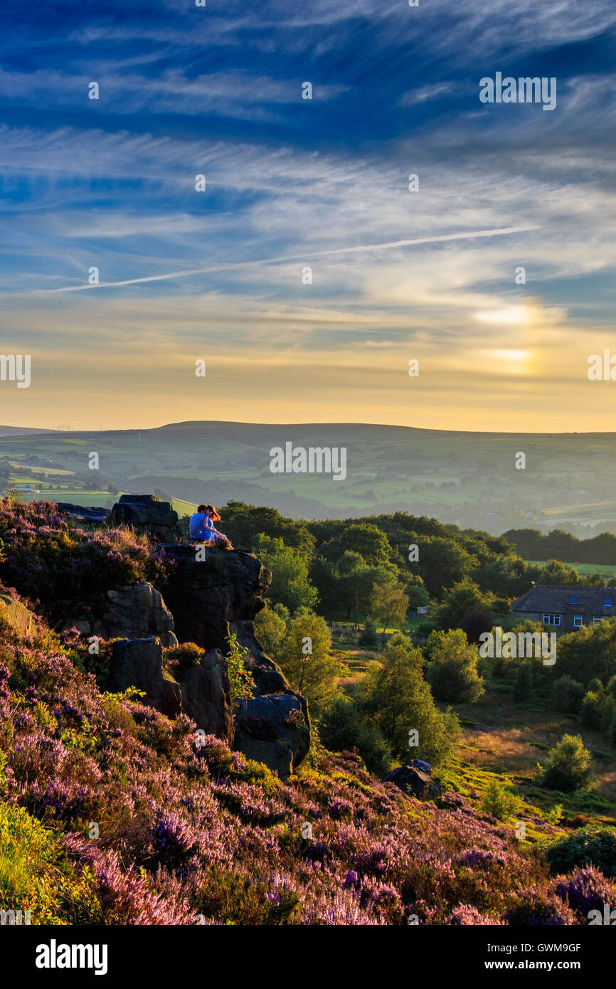 A couple sit on the rocks looking at the Beautiful sunset on Norland ...