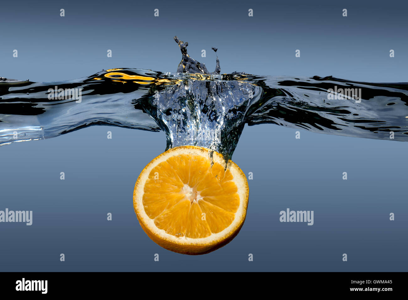 tropical fruit orange in water on a blue background Stock Photo - Alamy
