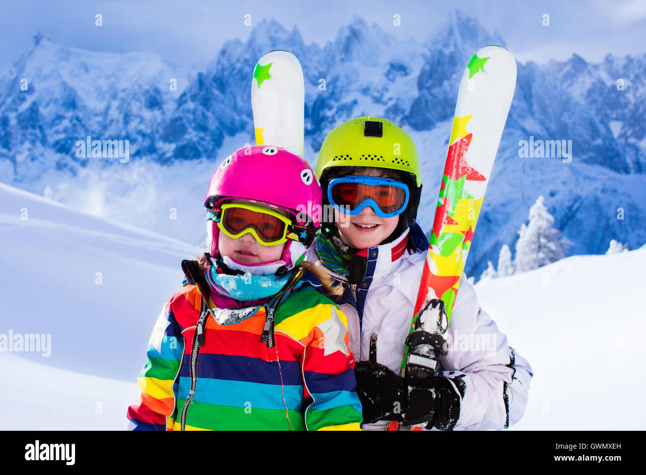 Boy and girl skiing in mountains. Toddler kid and teenager with helmet ...