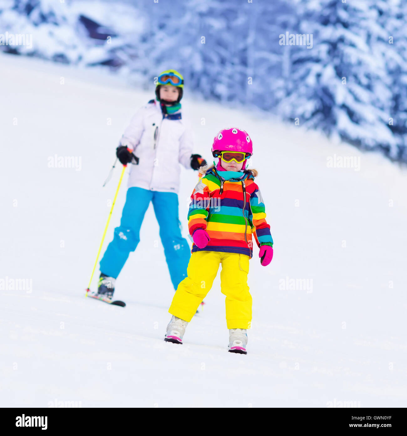 Boy and girl skiing in mountains. Toddler kid and teenager with helmet ...