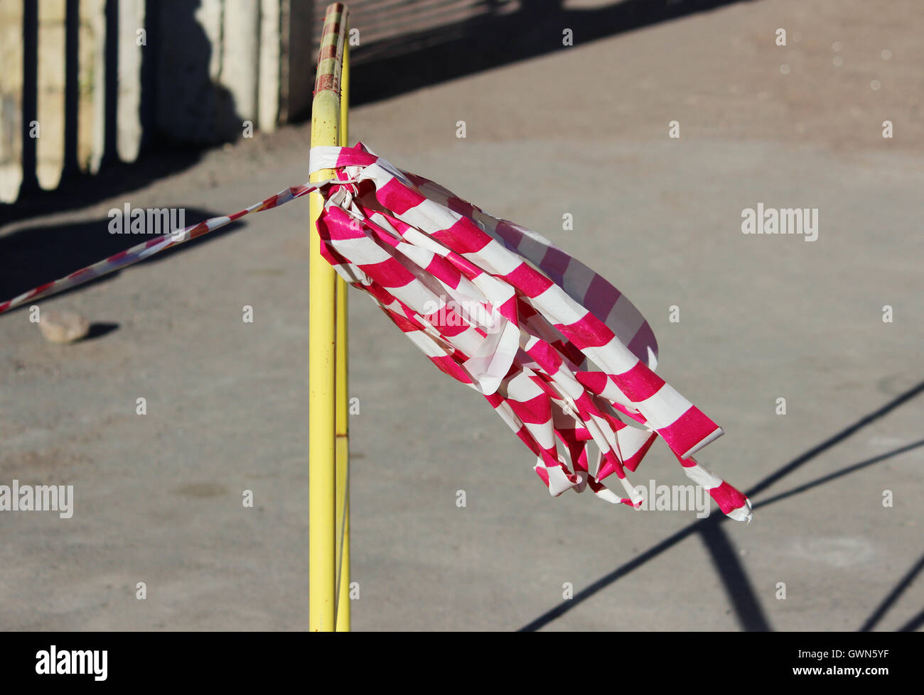 red white warning tape fencing is attached on a yellow fence Stock ...