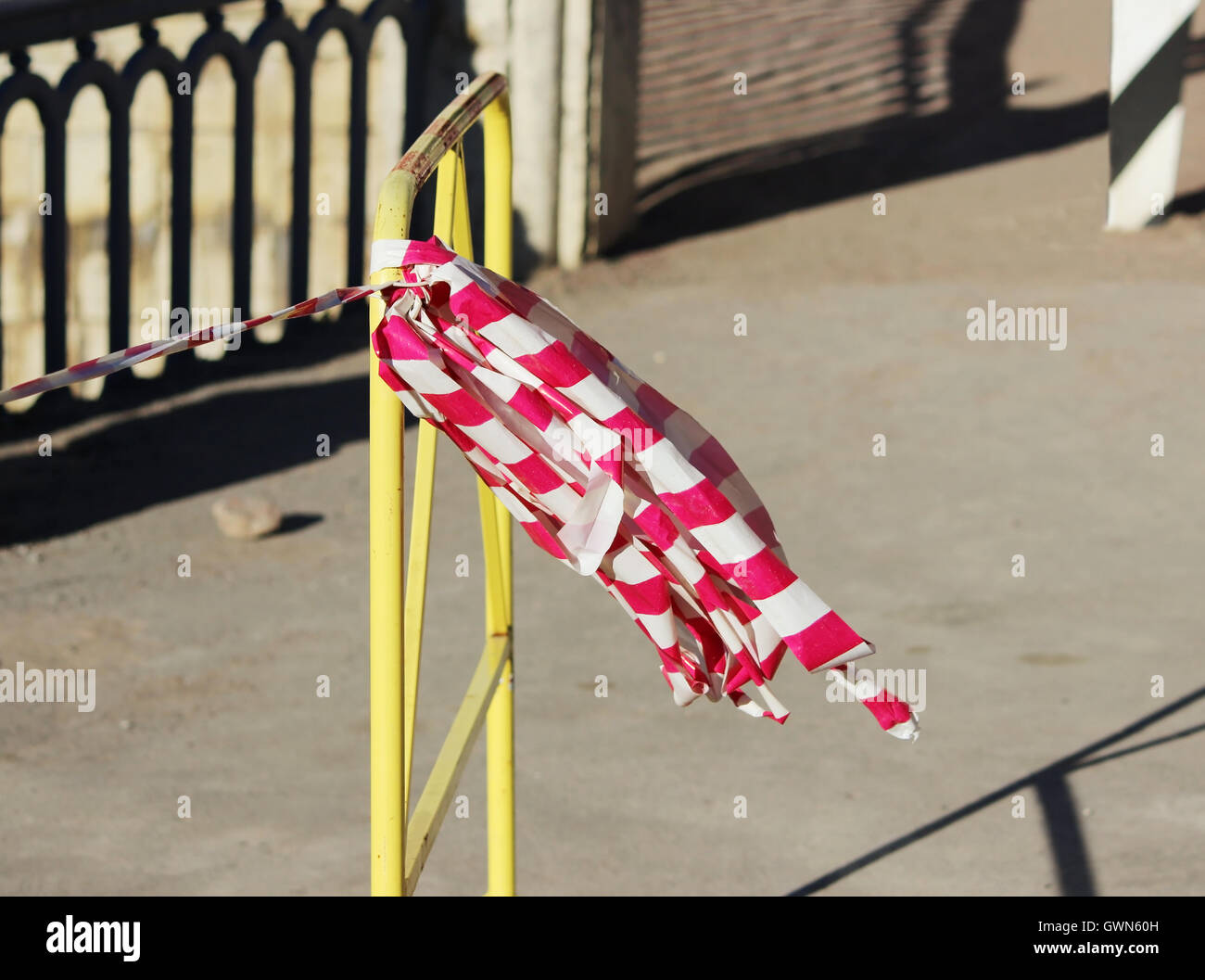 red white warning tape fencing is attached on a yellow fence Stock ...