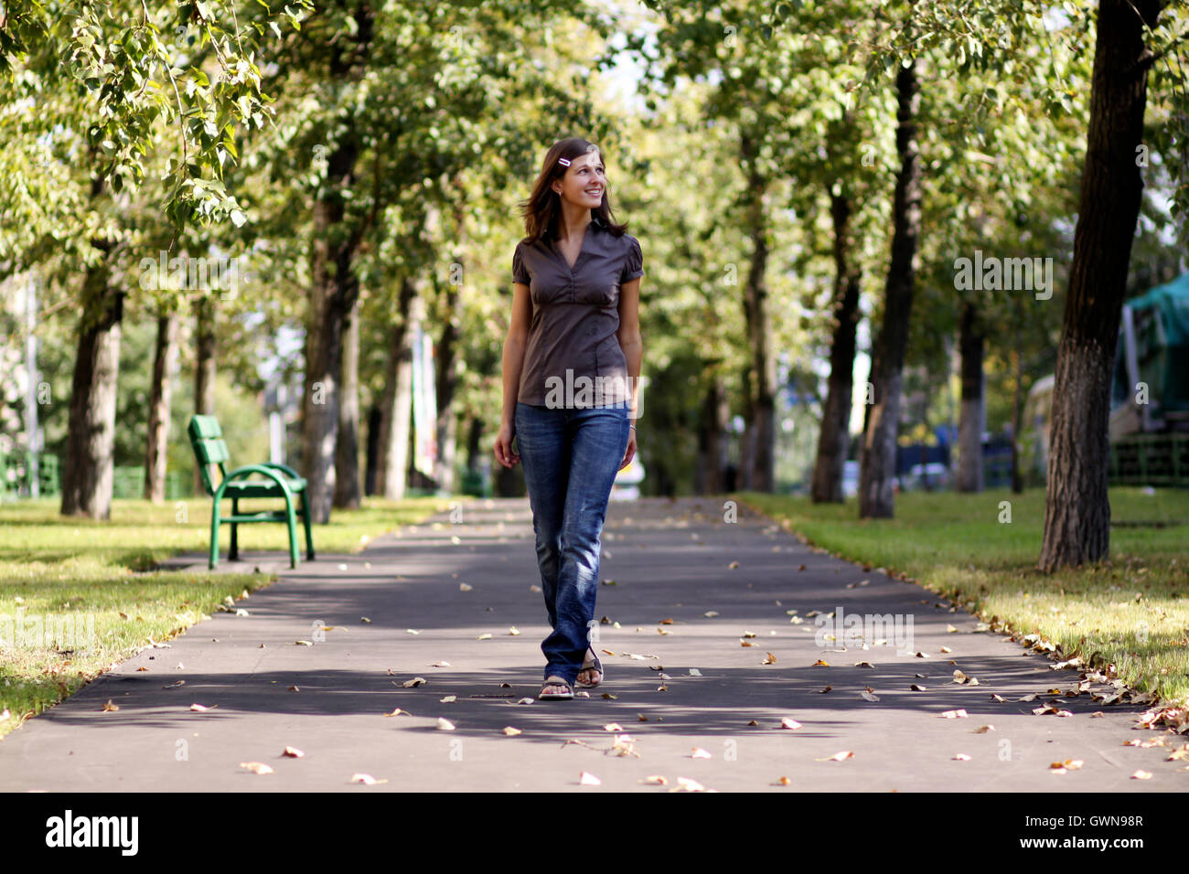 Full length, walking woman in autumn park Stock Photo - Alamy