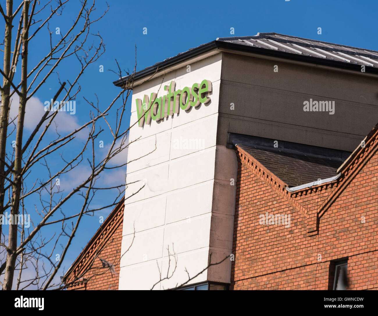 Waitrose supermarket sign large green on building wall with blue sky ...