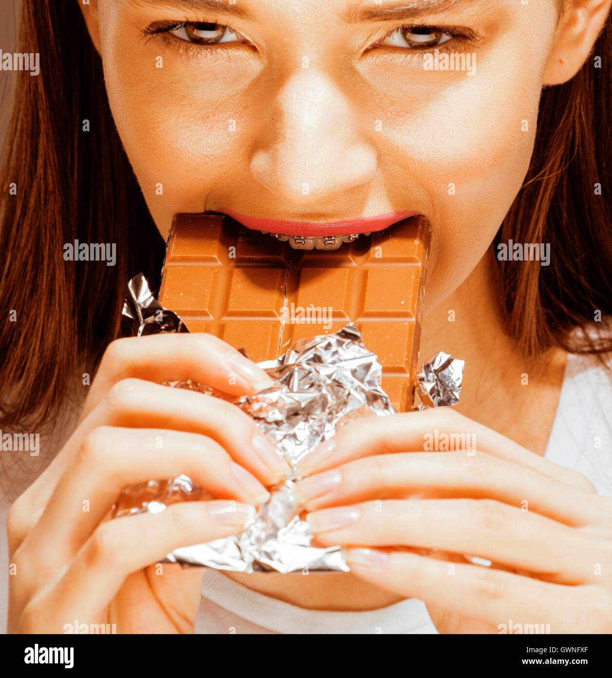 woman eating chocolate, close up hands with manicure french nails ...