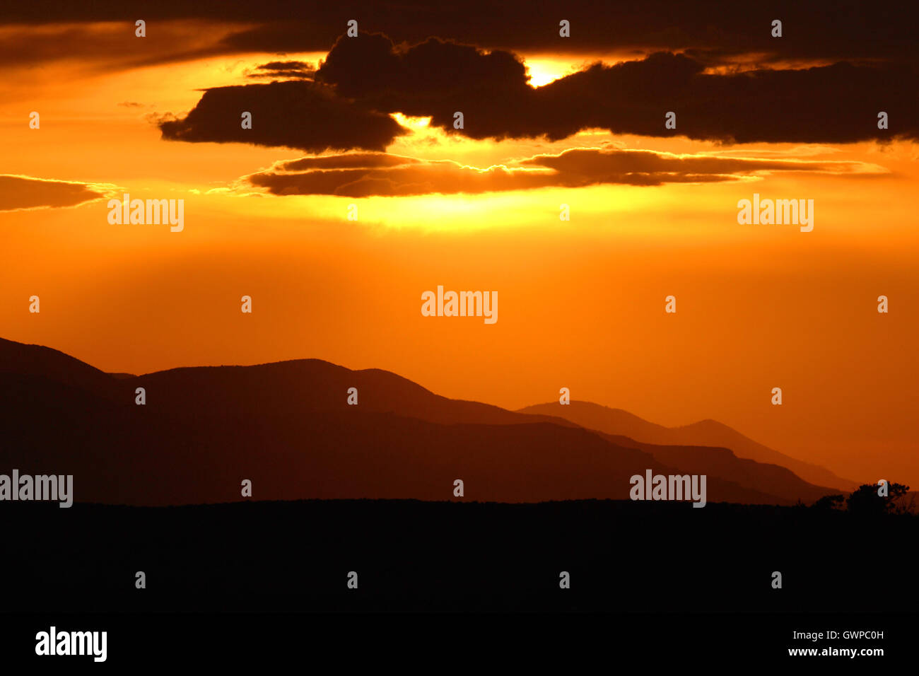 A soft, orange sunset along a line of Colorado foothills Stock Photo ...