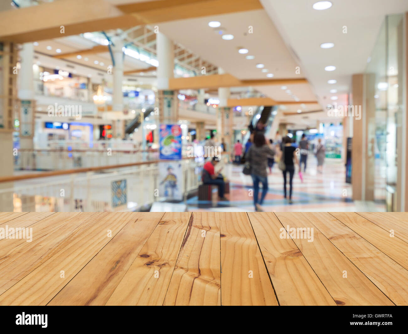 Wooden table with blurred shopping mall background Stock Photo - Alamy