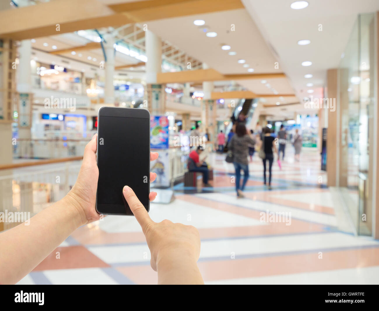 Woman's hands using smartphone in shopping mall Stock Photo - Alamy
