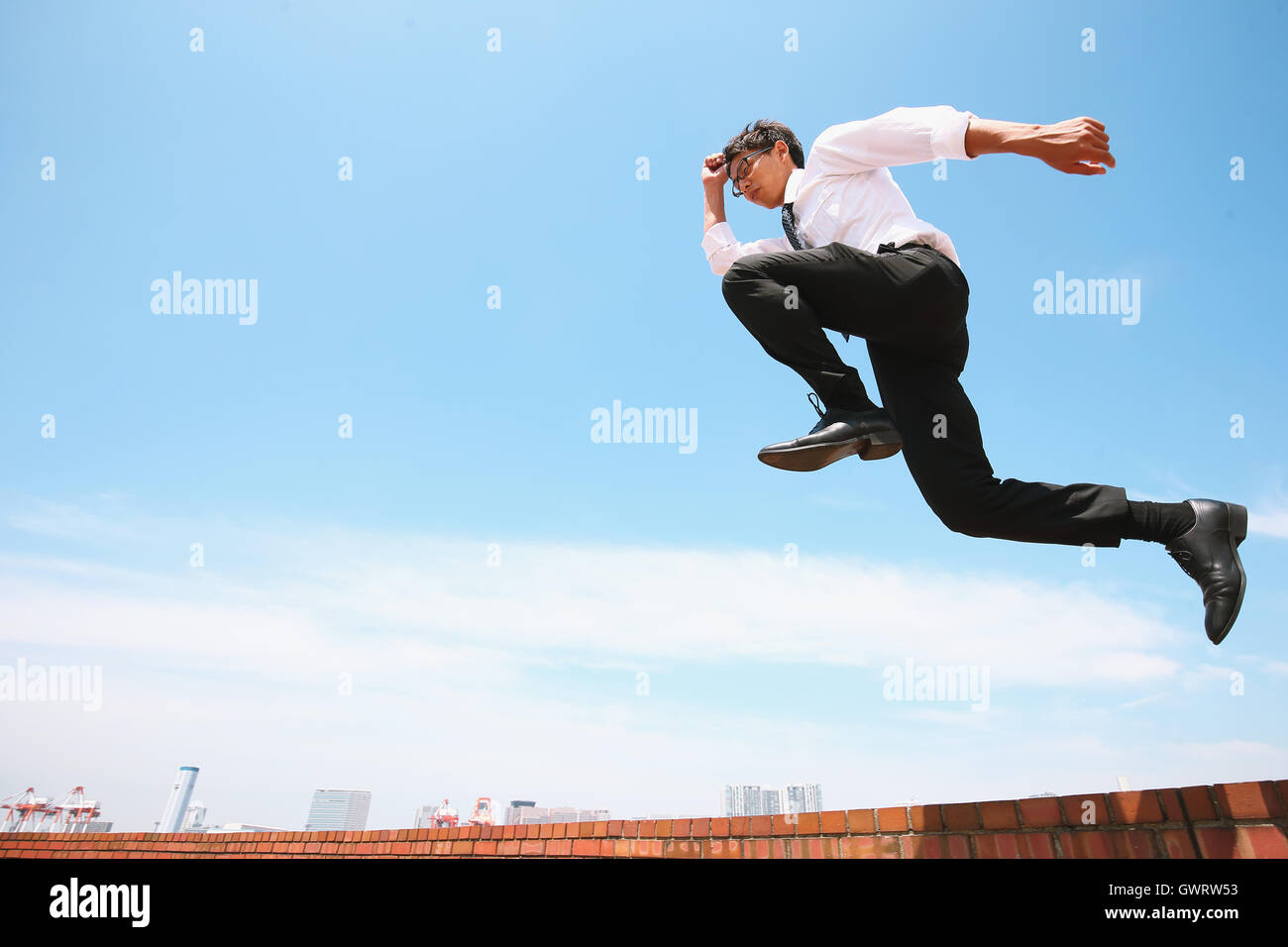 Young Japanese businessman jumping Stock Photo - Alamy