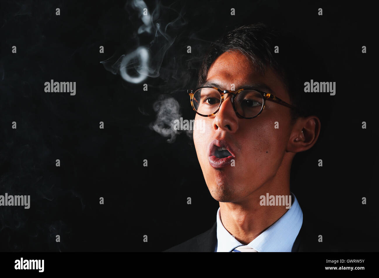 Young Japanese businessman smoking cigarette Stock Photo - Alamy