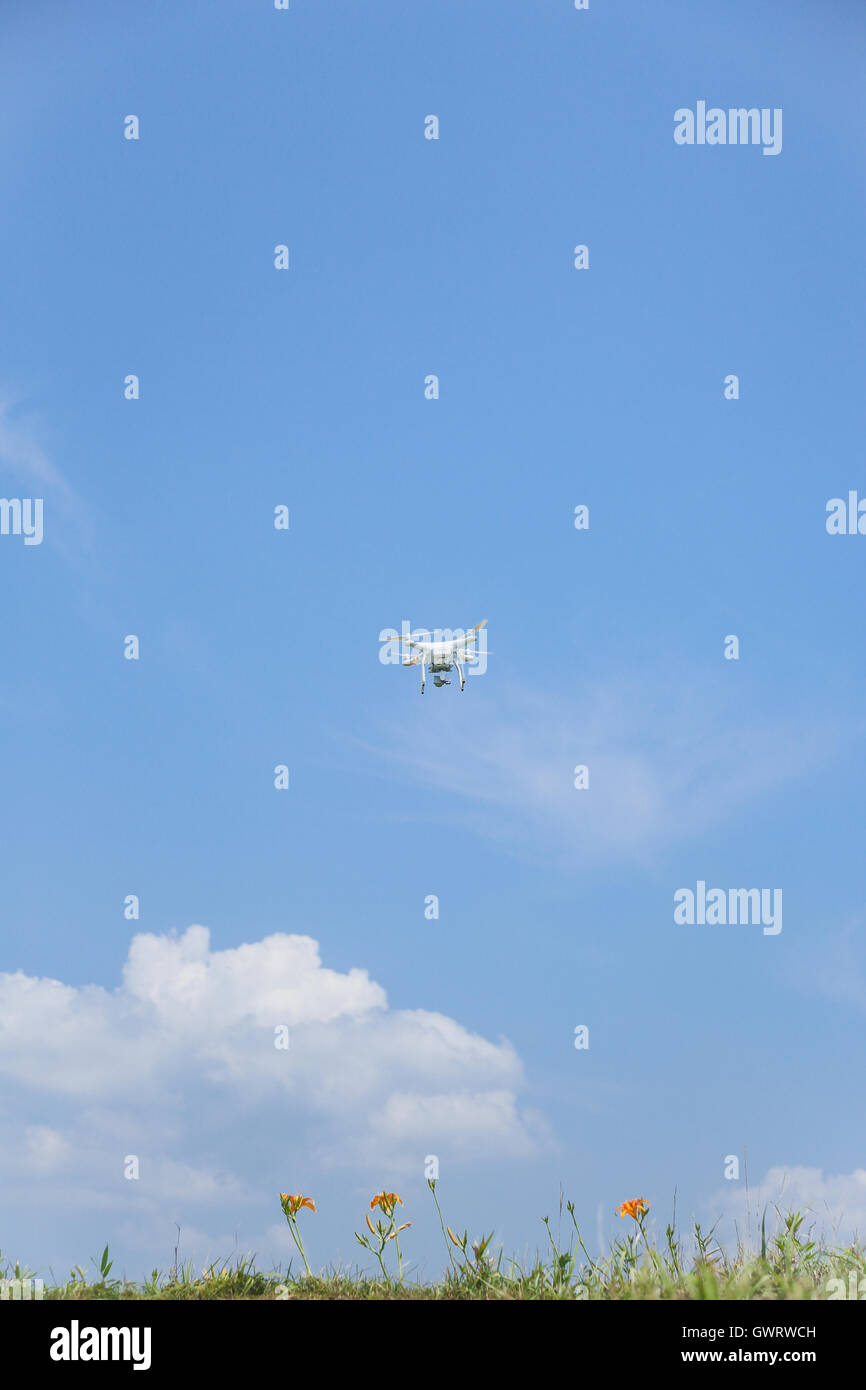 Drone flying in the blue sky Stock Photo - Alamy
