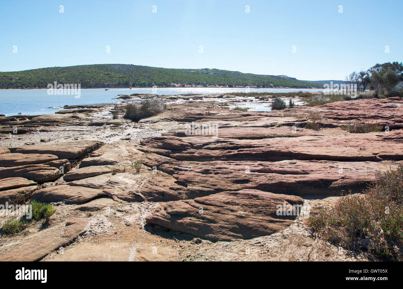 Red, rugged sandstone on the banks of the Murchison River with coastal ...