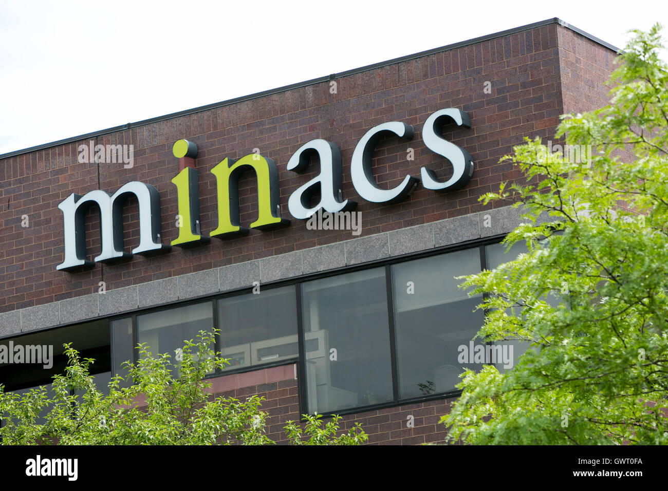 A logo sign outside of a facility occupied by Minacs in Farmington ...