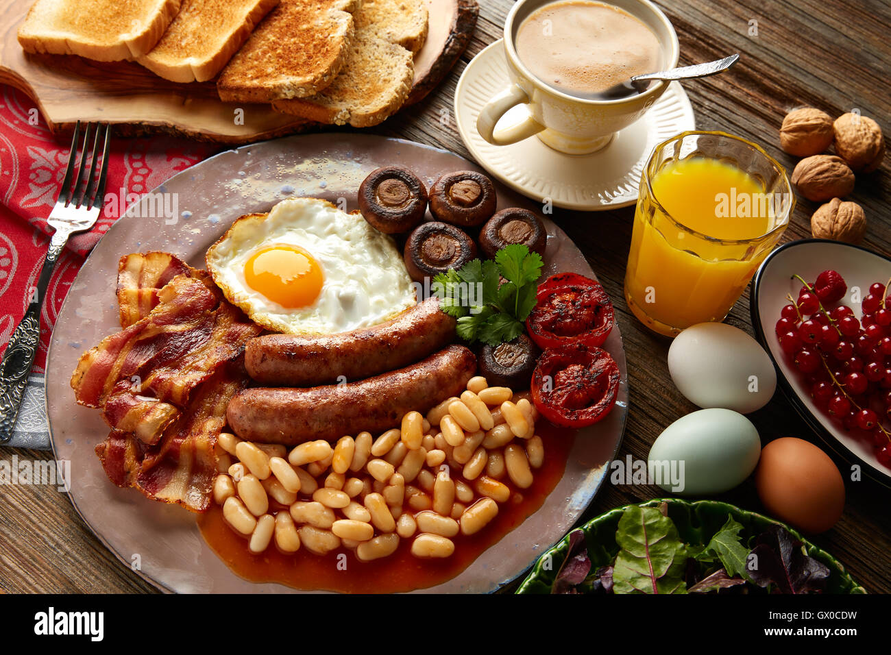 English breakfast with sausages egg beans bacon mushrooms and grilled ...