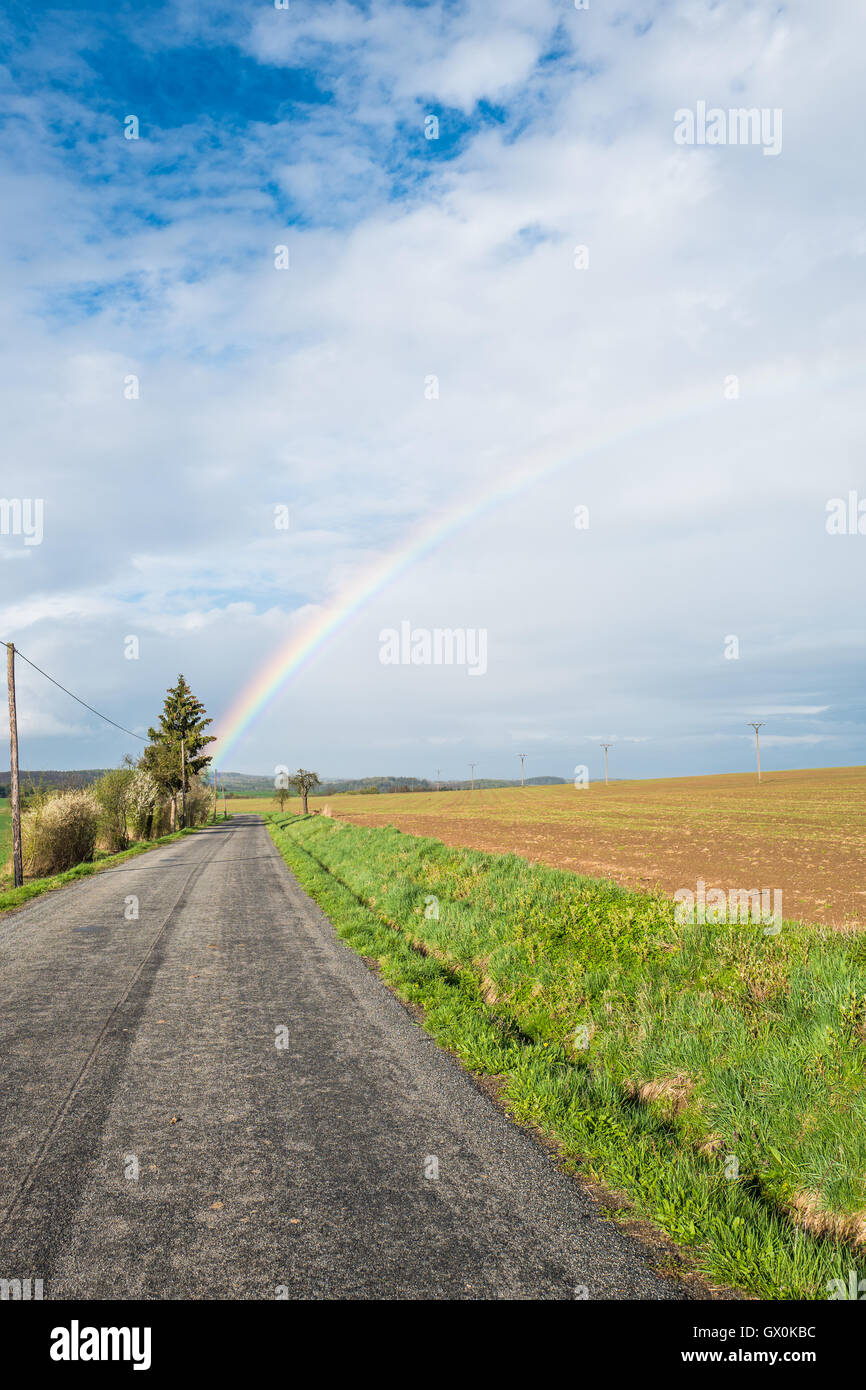 Rainbow over a field Stock Photo - Alamy