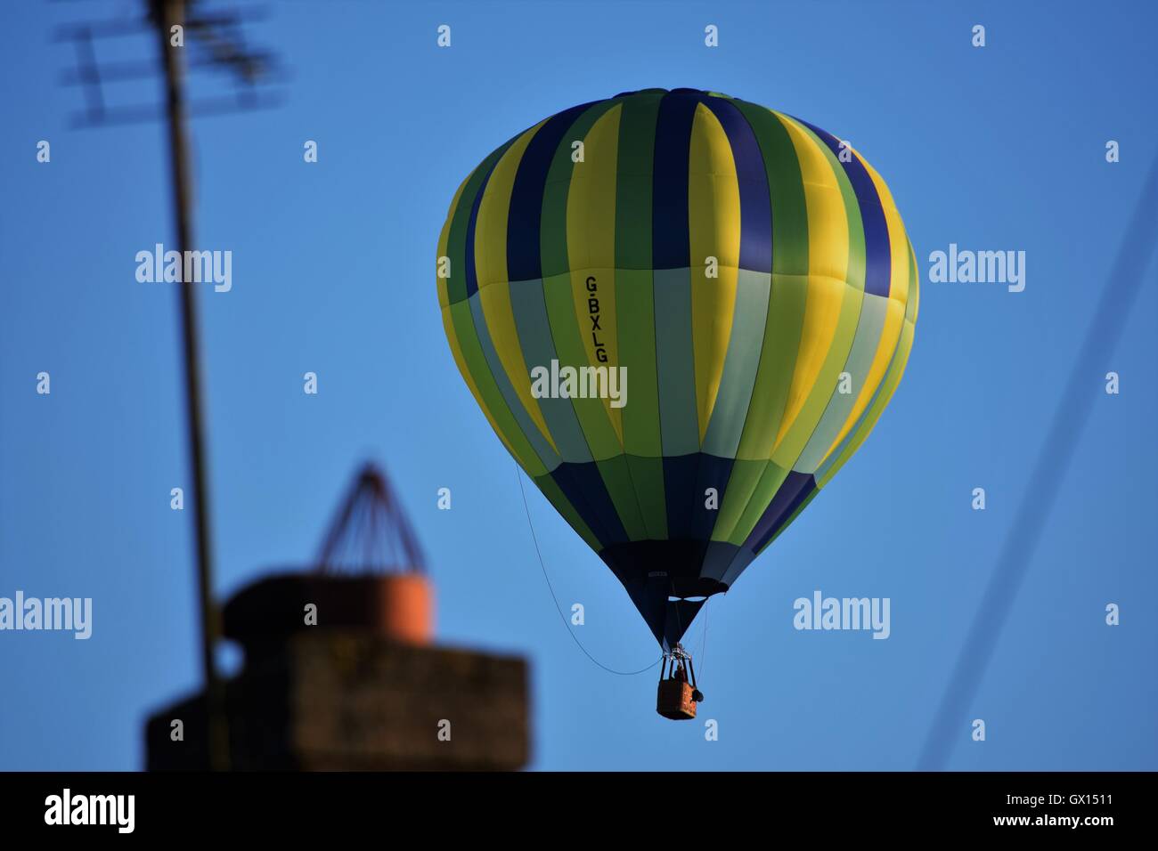 A hot air balloon floating over the back of a cottage Stock Photo - Alamy