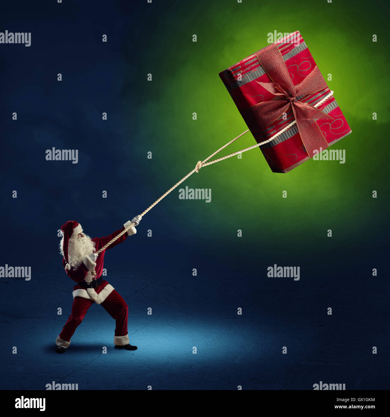 Santa Claus pulls a box with a gift Stock Photo - Alamy