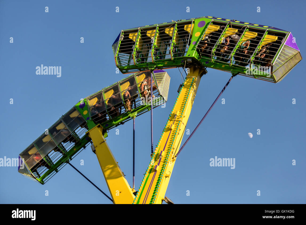 Children hang on as they ride the Kamikaze Pendulum amusement ride at ...