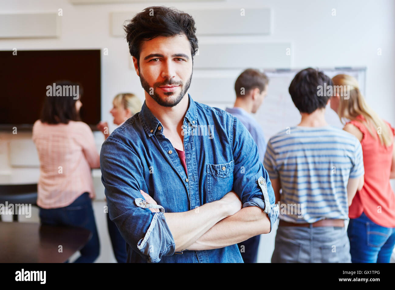 Man as successful student in seminar with arms crossed Stock Photo - Alamy