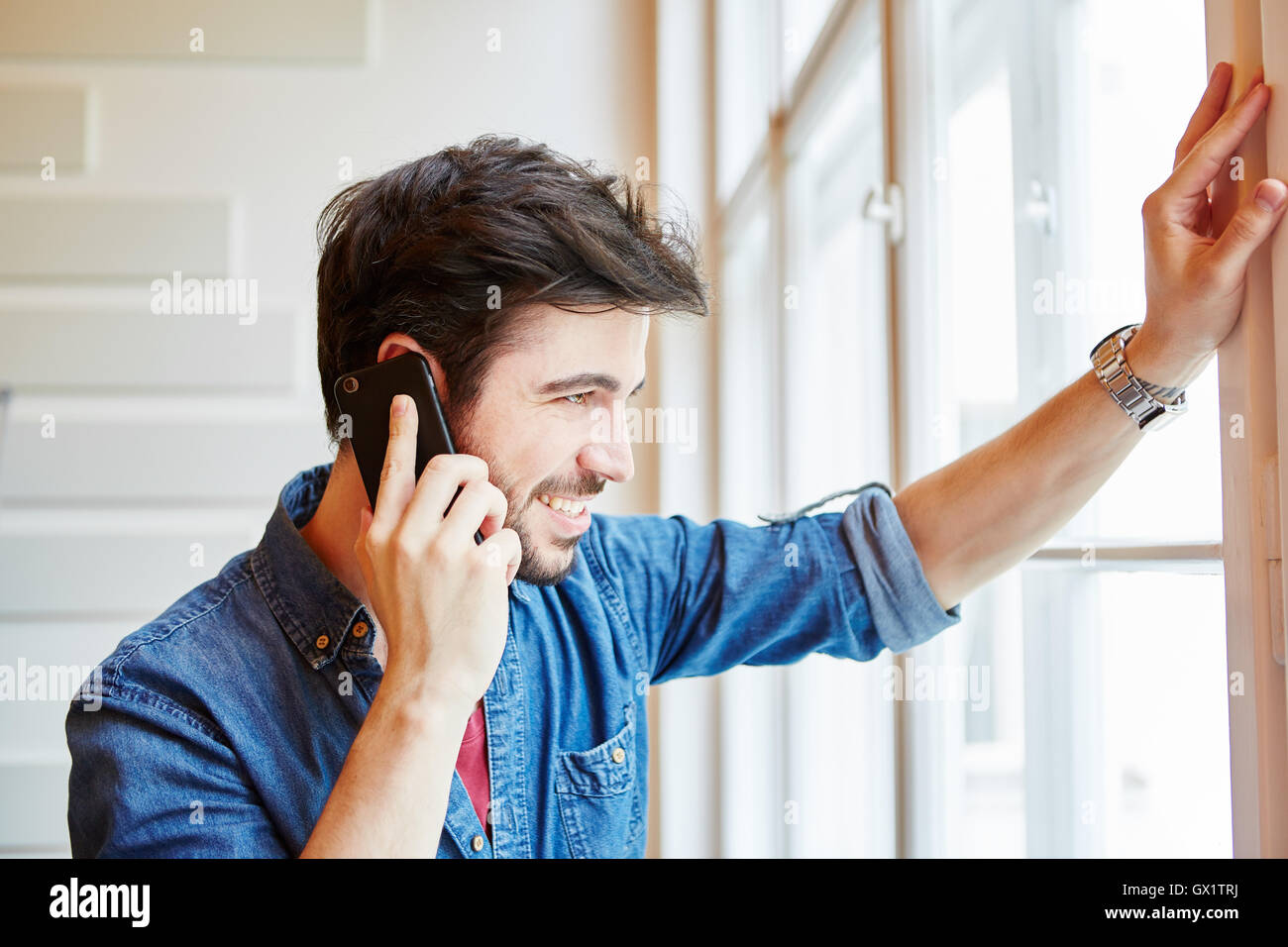 Young man calling with smartphone and thinking Stock Photo - Alamy