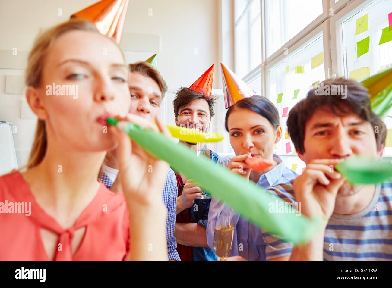 Group of students celebrating with noisemakers in party Stock Photo - Alamy