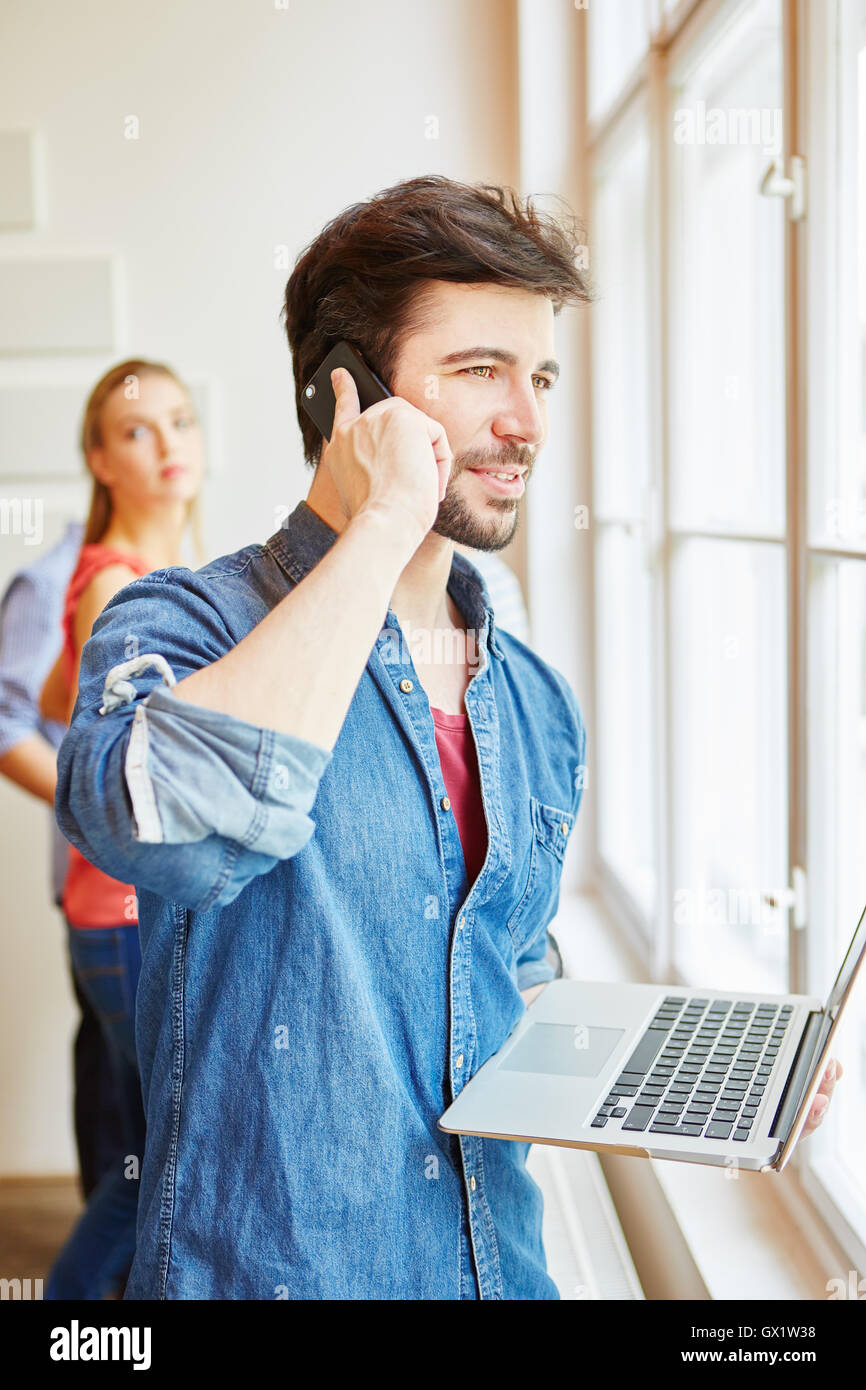 Business man founder with laptop calling on the phone in his start-up ...