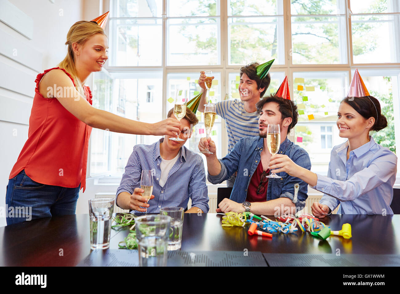 Friends celebrating with champagne in start-up birthday party Stock ...