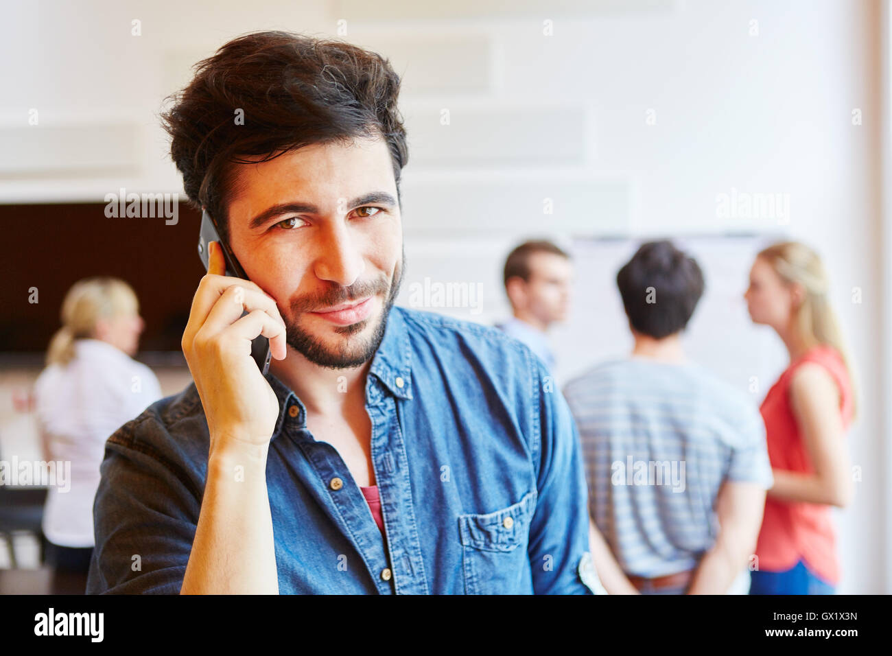 Young man as entrepreneur calling with smartphone Stock Photo - Alamy