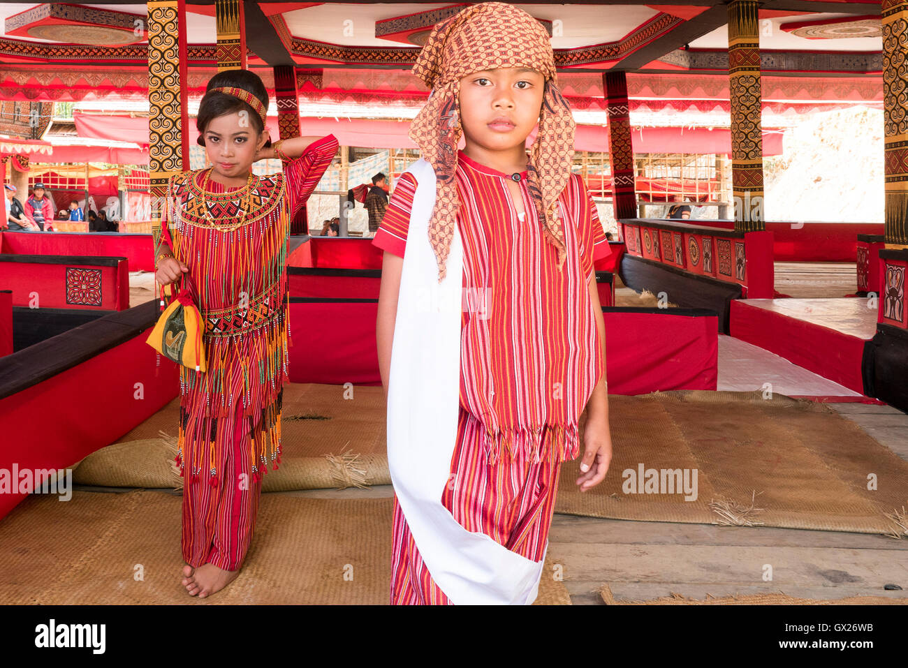 Portrait of two young Torajan pose for camera with traditional costume ...