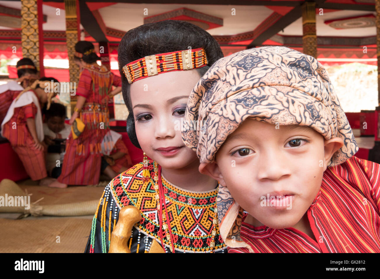 Portrait of two young Torajan pose for camera with traditional costume ...