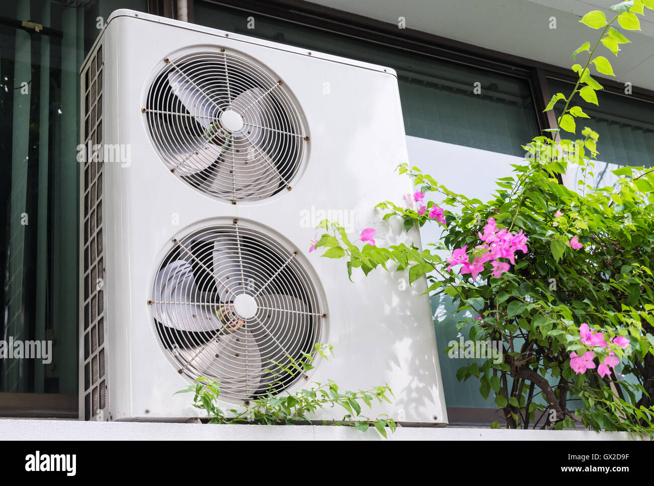 Double fan system of the air compressor unit near the window outside ...