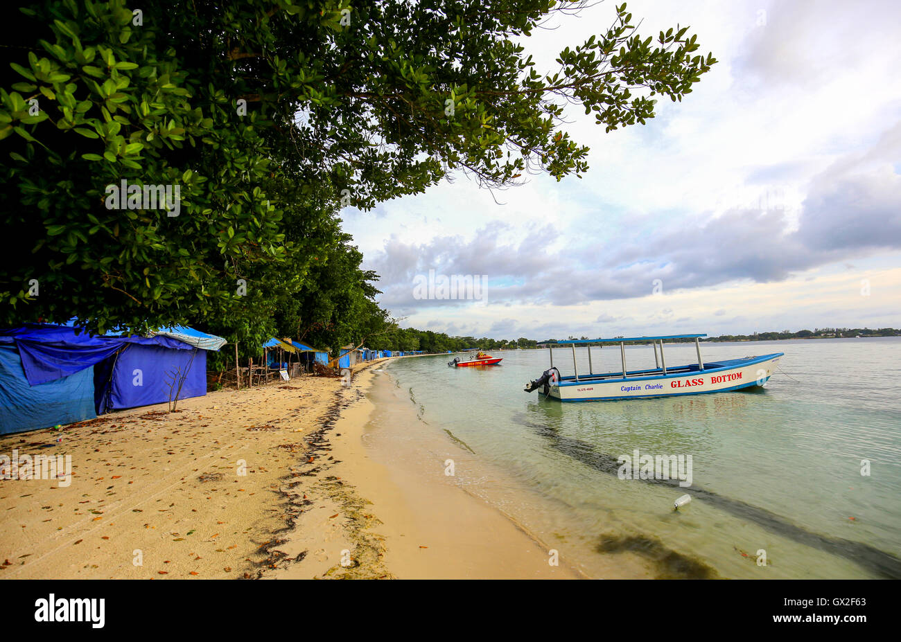 Shoreline in Jamaica with boat and closed merchant booths Stock Photo ...