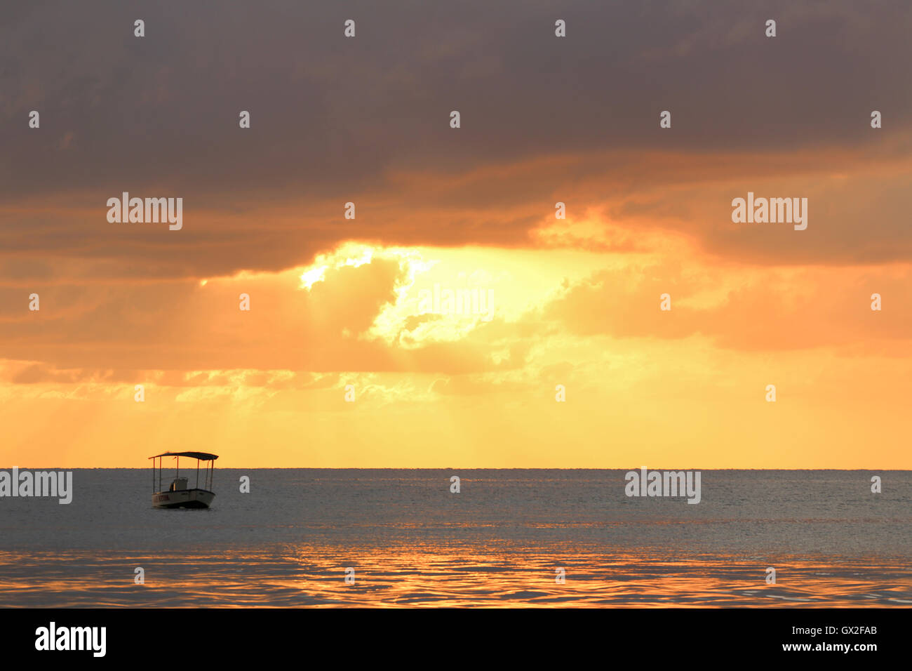 Ocean sunset with clouds in gold colors with boat silhouette Stock ...