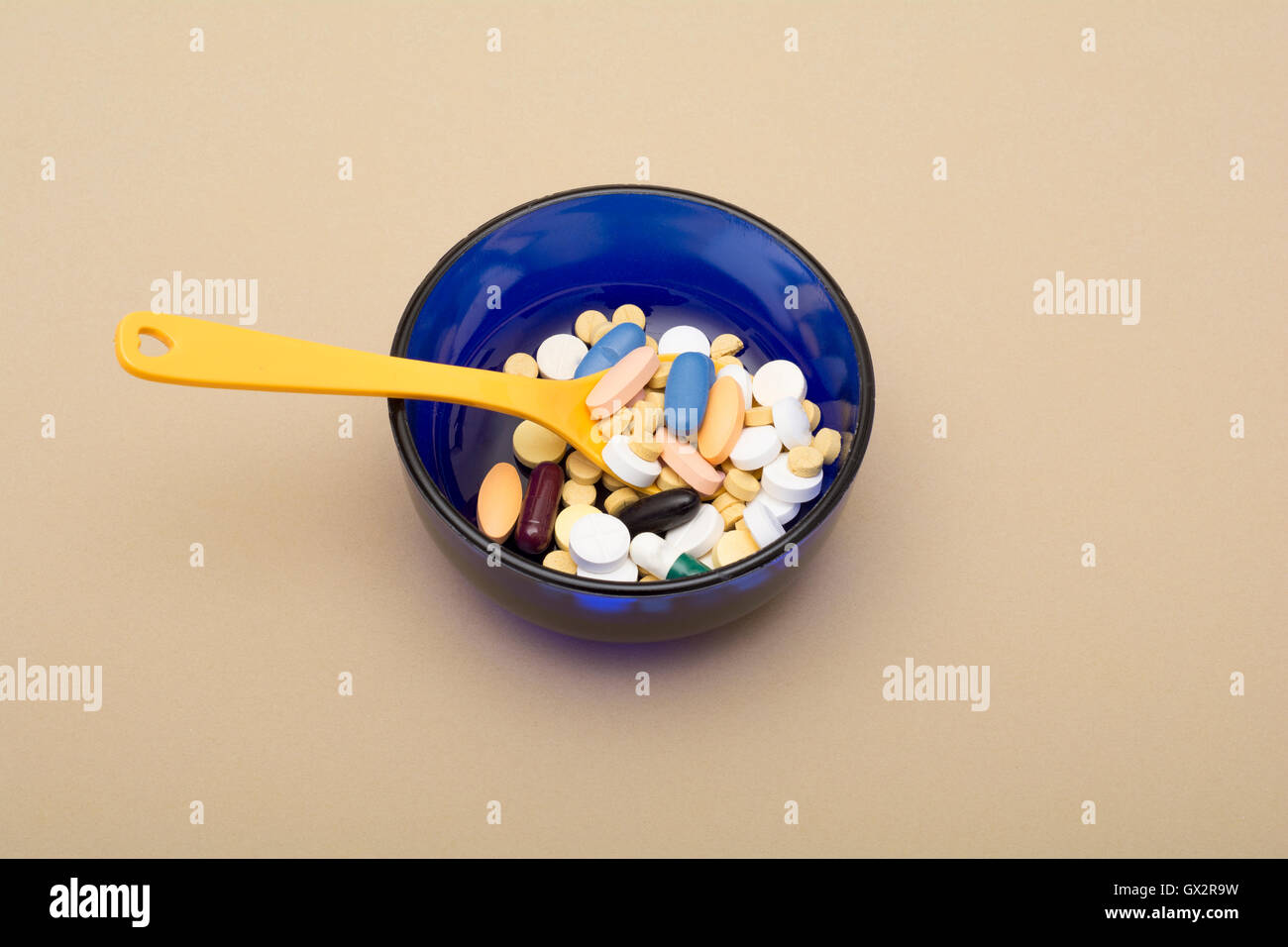 A Bowl full of tablets and capsules on cream background Stock Photo - Alamy