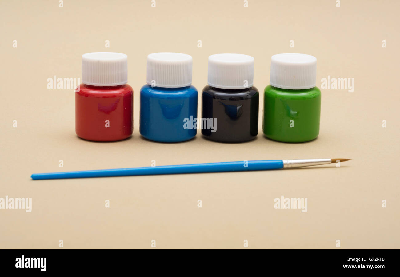 Four paint bottles in prime colors with painting brush Stock Photo - Alamy
