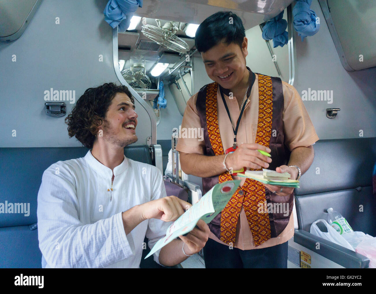 Customer and railway official on a train in Thailand Stock Photo - Alamy