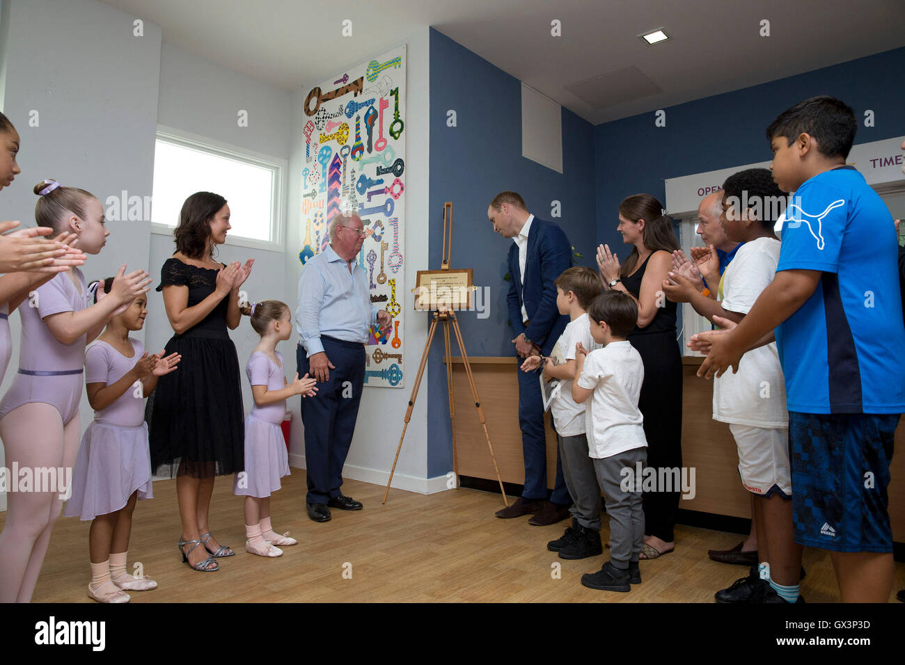 The Duke of Cambridge unveils a plaque during a visit to Caius House ...