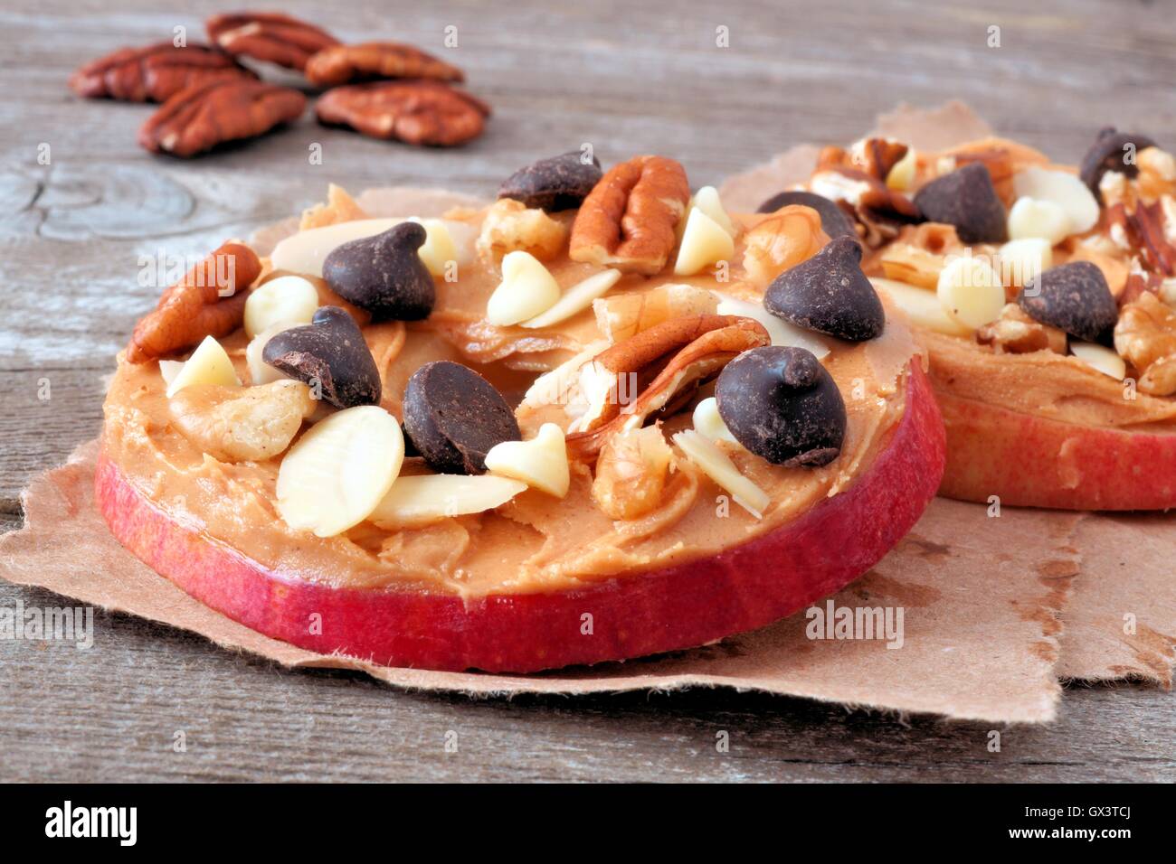 Autumn apple rounds close up with peanut butter, chocolate chips and ...