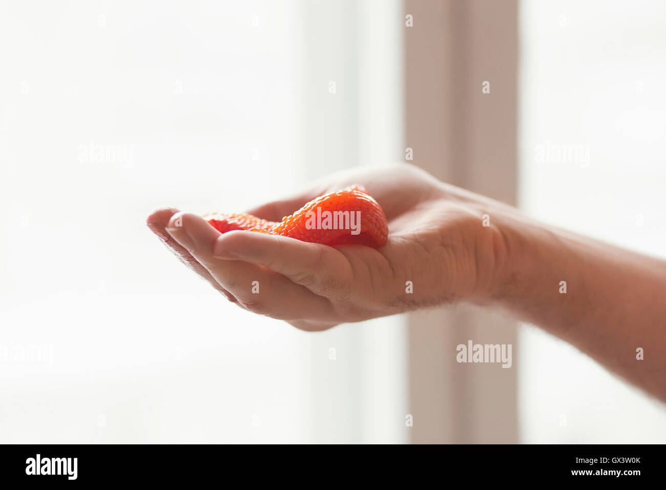 red caviar on a hand at light background Stock Photo - Alamy