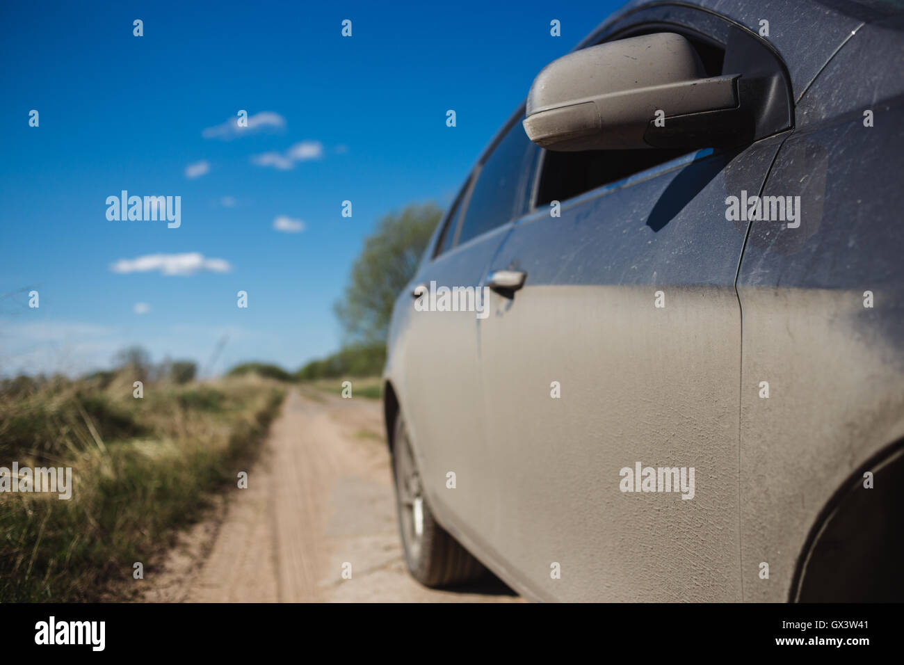 car side view in dust and blured summer field on ground road Stock ...