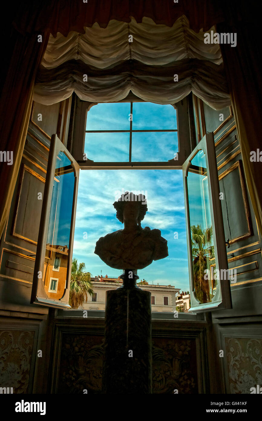 A bust stands in front of a window of a hall of the Colonna Palace, in ...